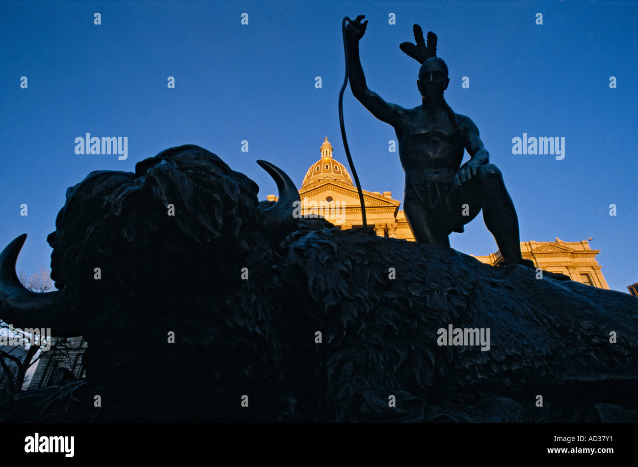 Silhouette of indian and buffalo statue with Colorado state capitol ...