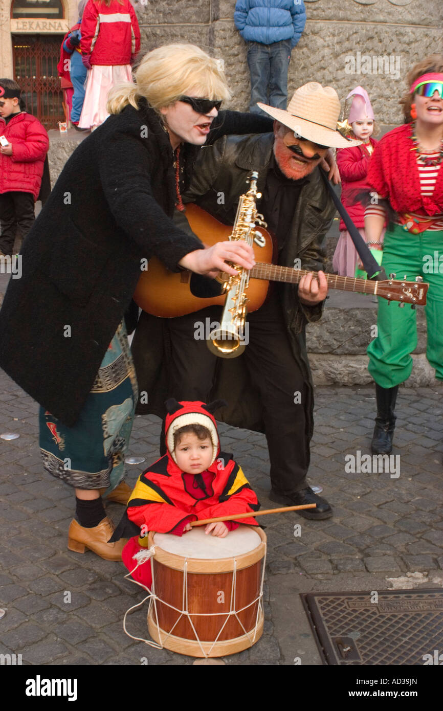 Little boy dressed as devil sits at drum while musicians behind play ...