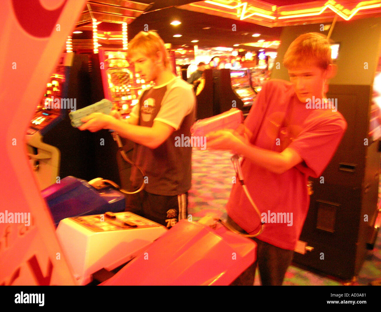 Boys using replica guns at arcade game, UK Stock Photo - Alamy