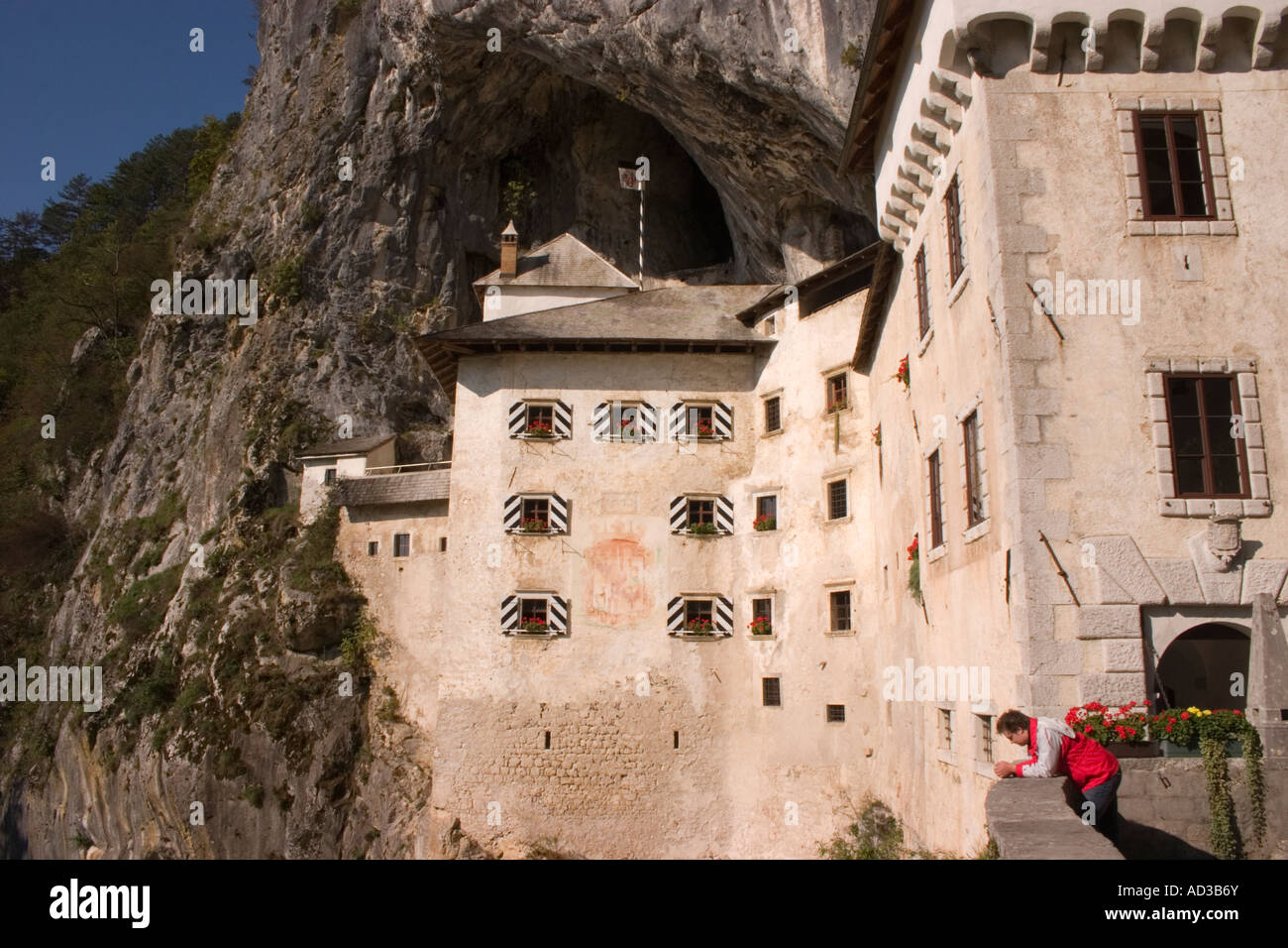 Man looking over wall in front of Predjama castle , Slovenia Stock ...