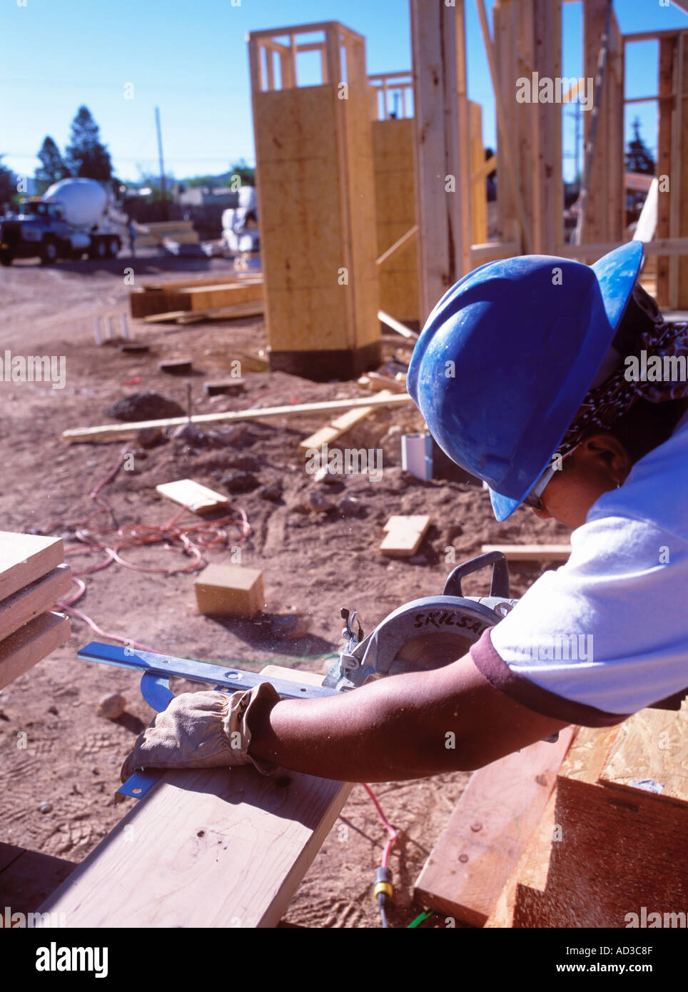 Construction worker cutting wood at job site Stock Photo - Alamy