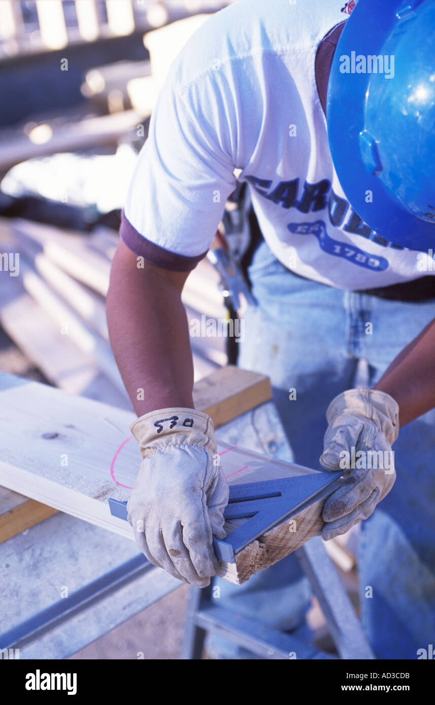 Construction worker cutting wood at job site Stock Photo - Alamy
