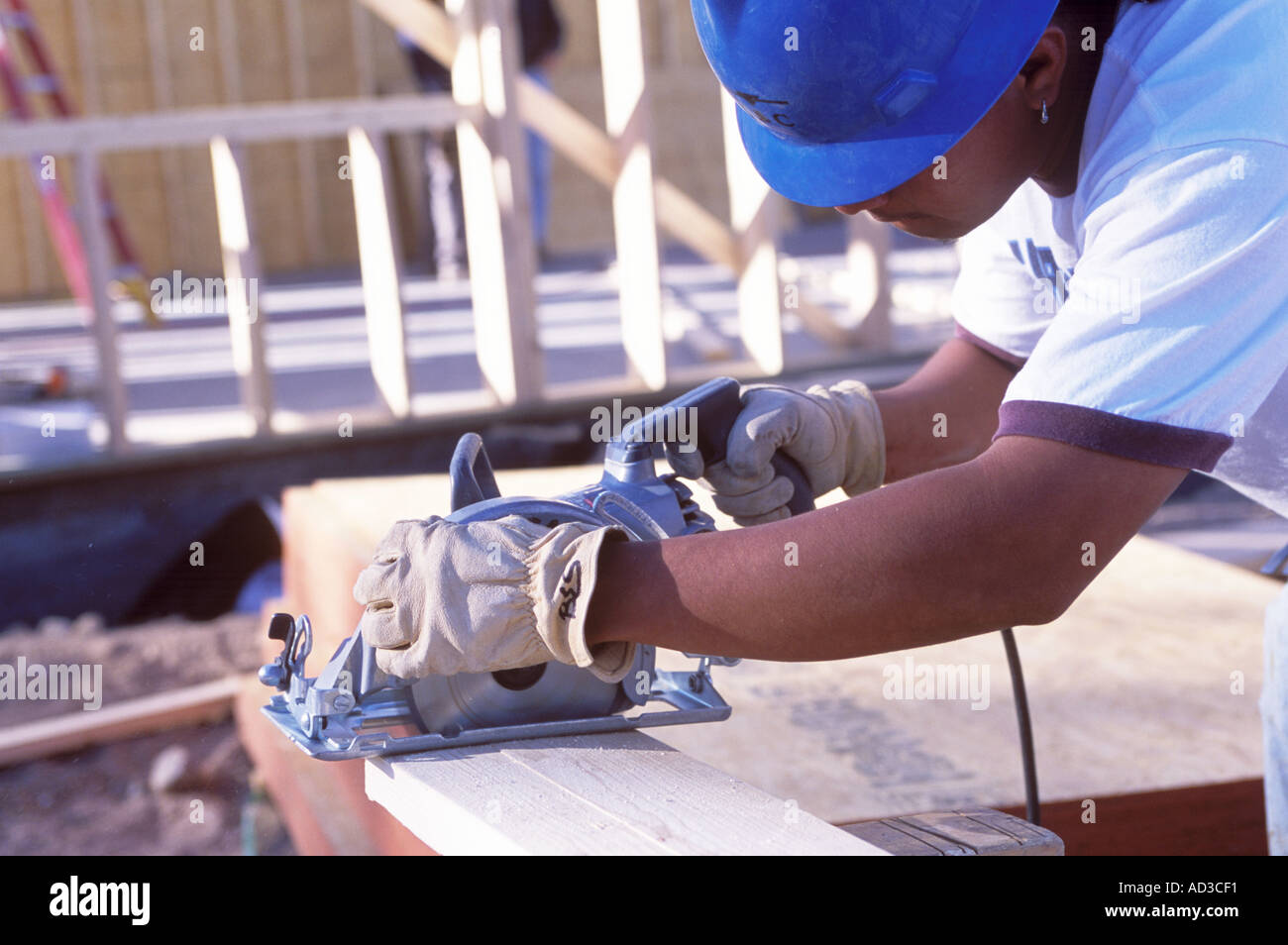 Construction worker cutting wood at job site Stock Photo - Alamy