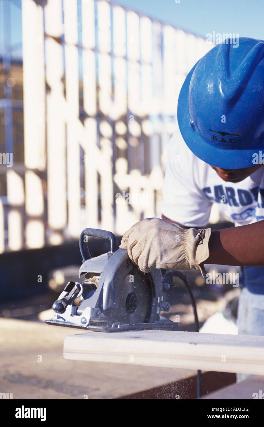 Construction worker cutting wood at job site Stock Photo - Alamy