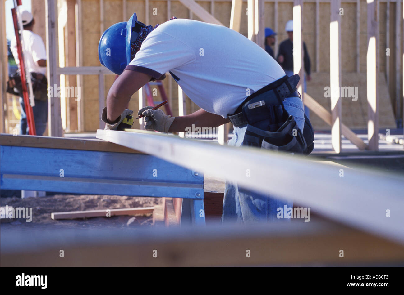 Construction worker cutting wood at job site Stock Photo - Alamy