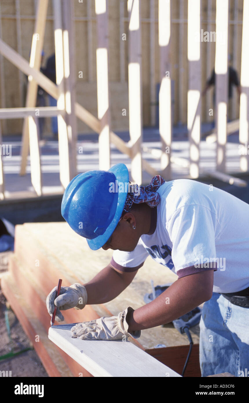 Construction worker cutting wood at job site Stock Photo - Alamy