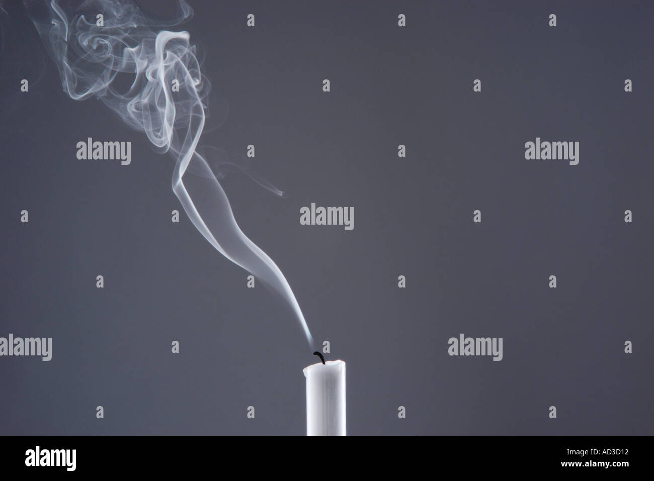 Candle flame just extinguished Grey background Stock Photo - Alamy