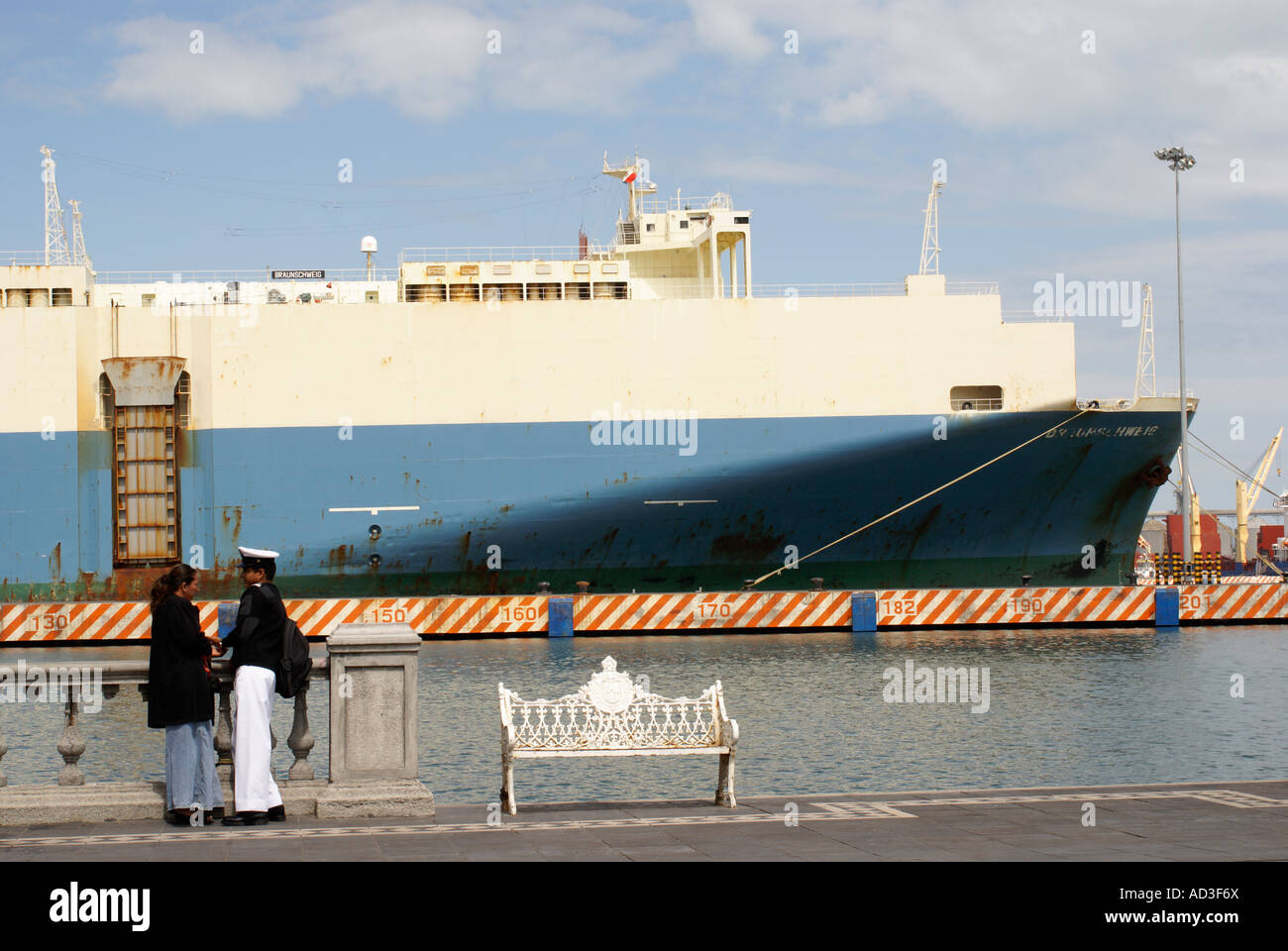 Mexican sailor and his girlfriend standing in front of a huge ship used ...