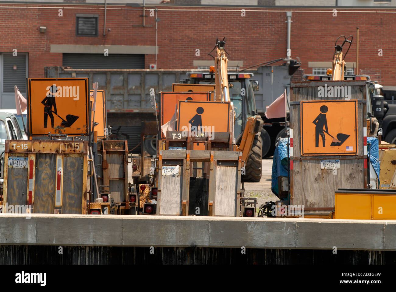 Men working signs with equipment at street maintenance storage yard ...