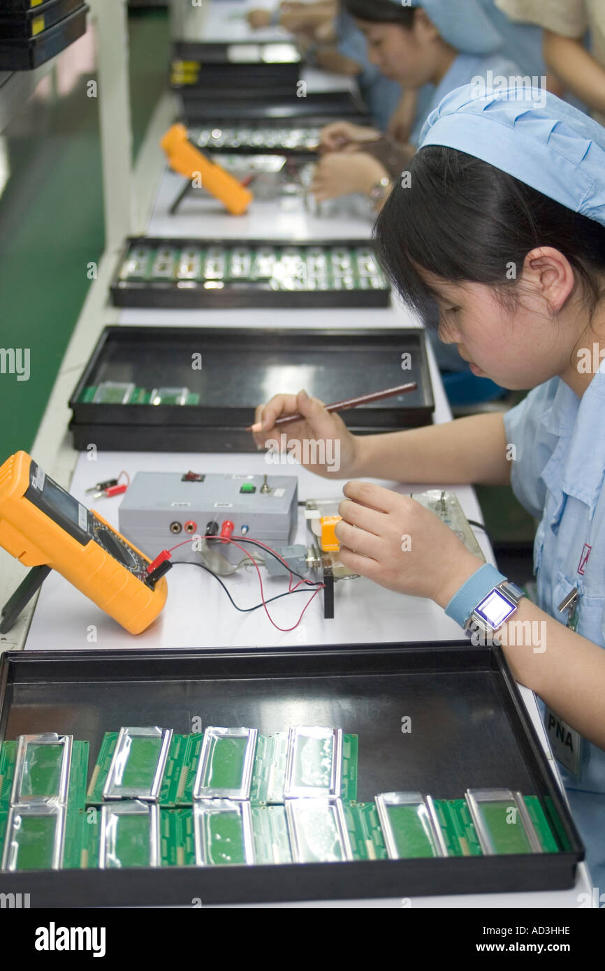 Chinese High Tech Factory Workers on Assembly line testing components ...