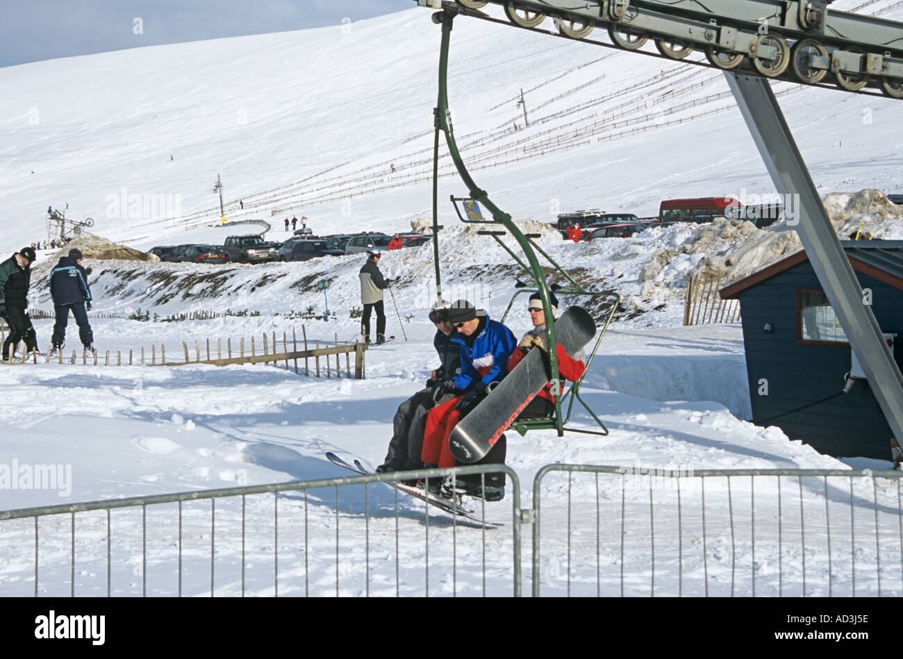 SCOTTISH HIGHLANDS UK February Three male skiers boarding a ski lift at ...