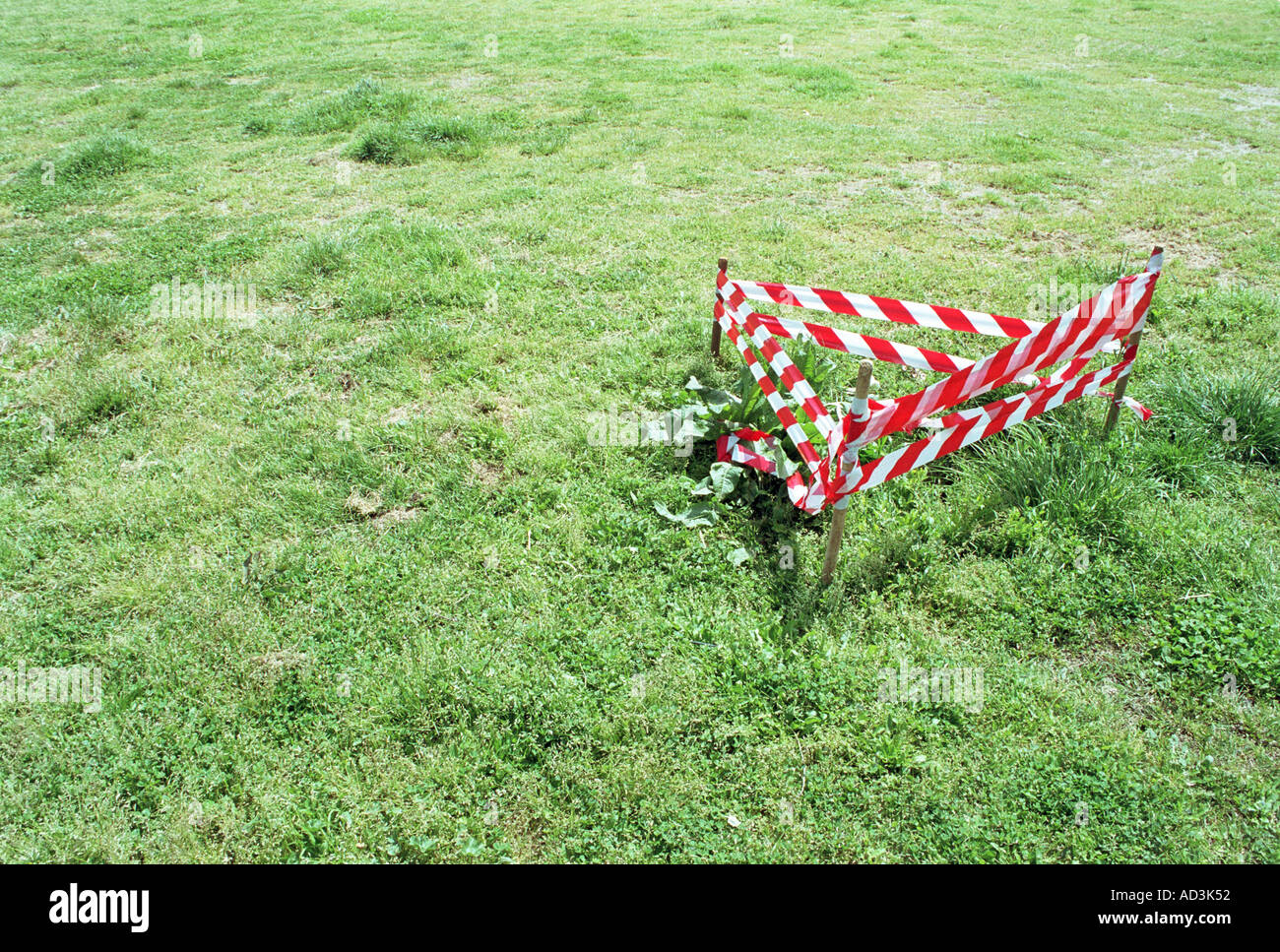 red white warning tape in triangle covering hole in park Stock Photo ...