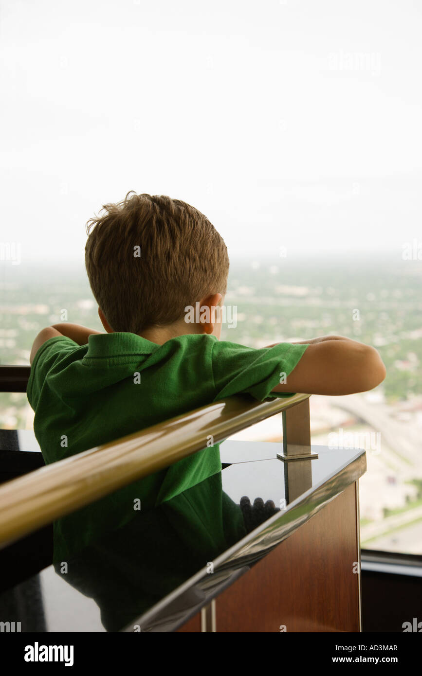 Young Caucasian boy leaning on railing at observation deck at Tower of ...
