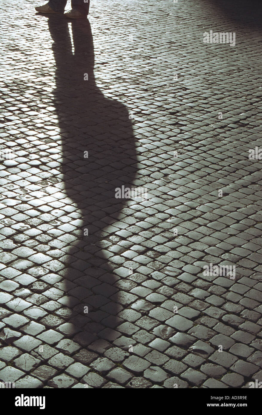 shadow of man walking on cobbled street Stock Photo - Alamy