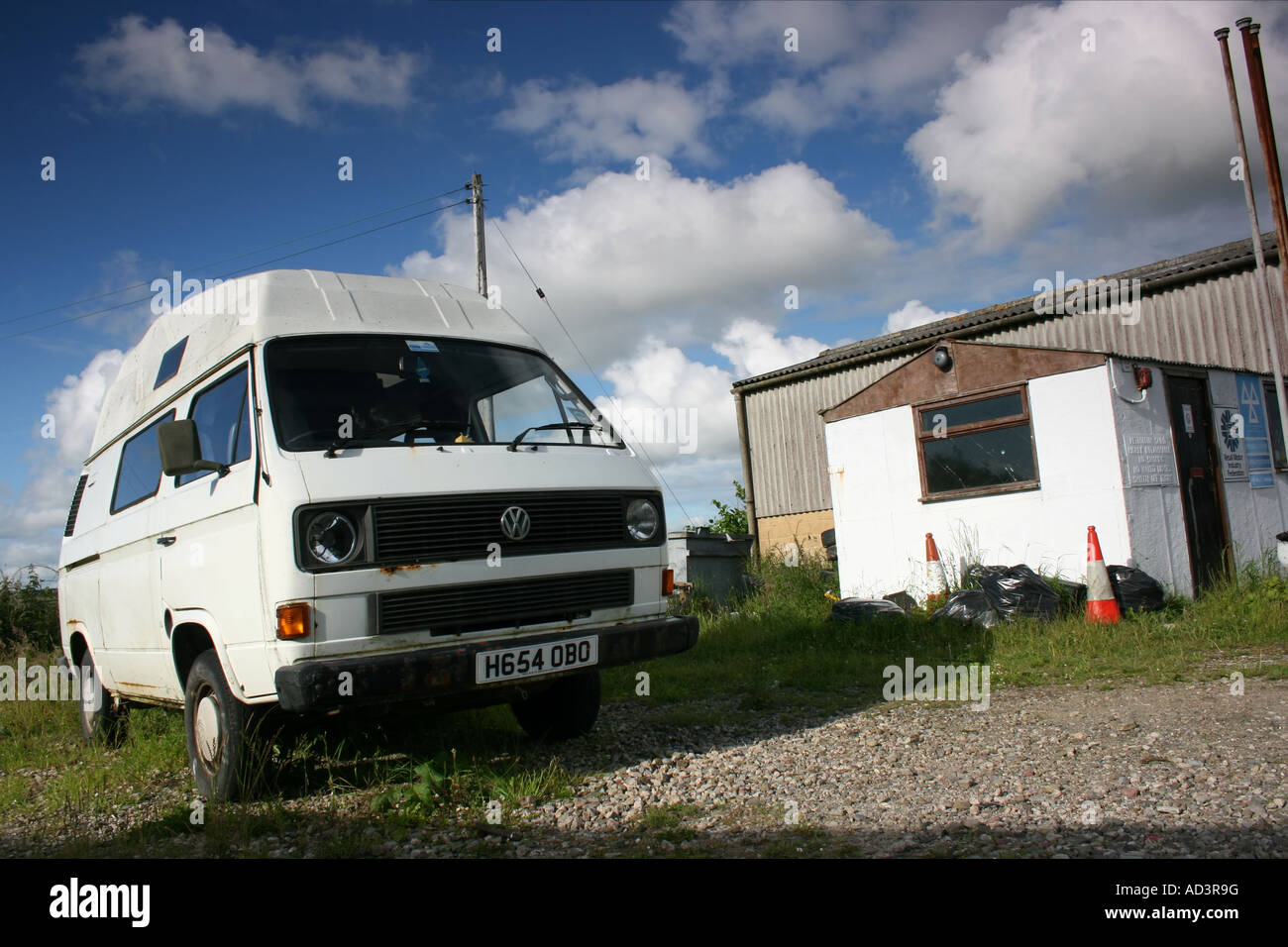 Beaten up old Volkswagen camper parked at old garage buildings ...