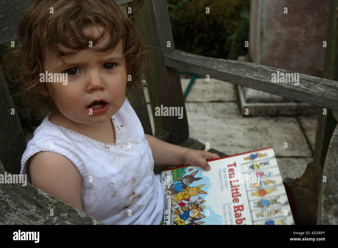 Small Girl Reading Book in the Garden Stock Photo - Alamy