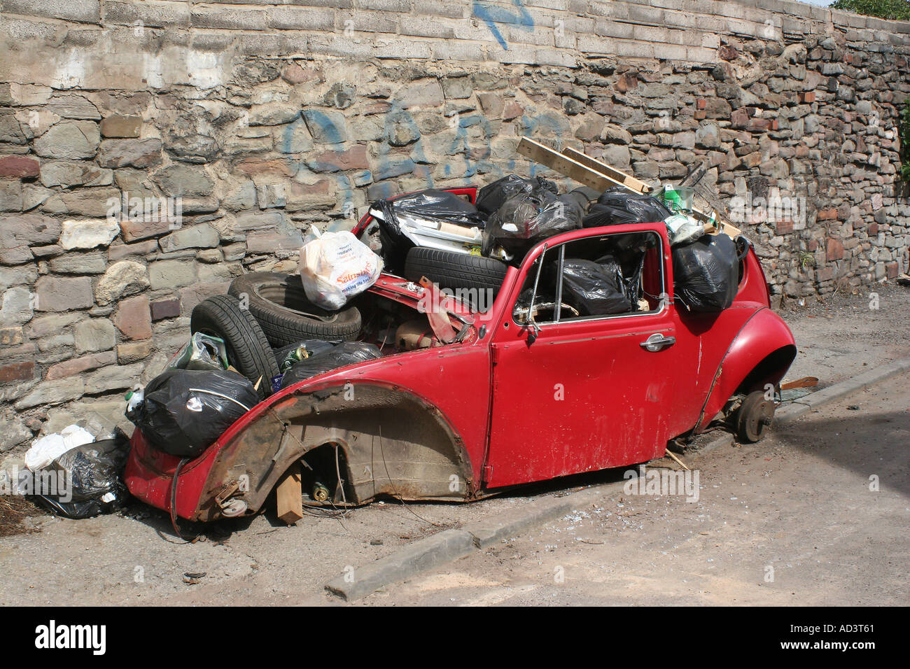 wrecked car dumped on side of street and filled with rubbish Stock ...