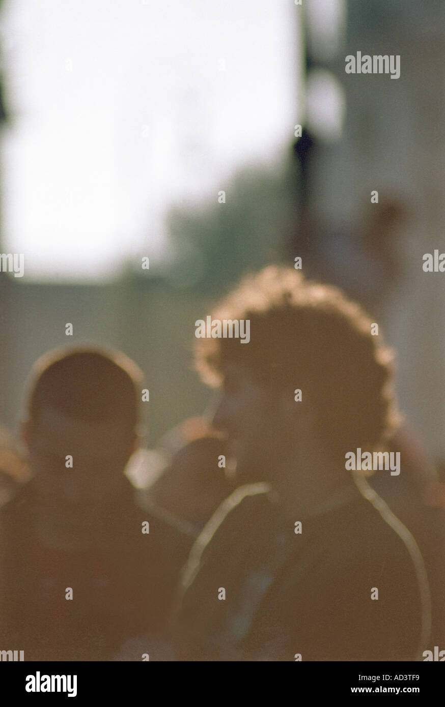 backlit view of man with curly hair in crowd abstract Stock Photo - Alamy