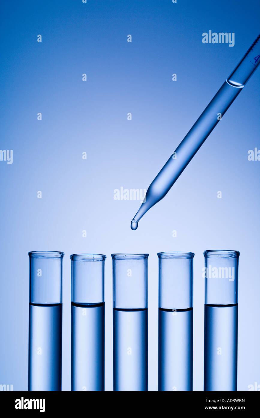 Dropper dropping liquid into test tube Stock Photo - Alamy