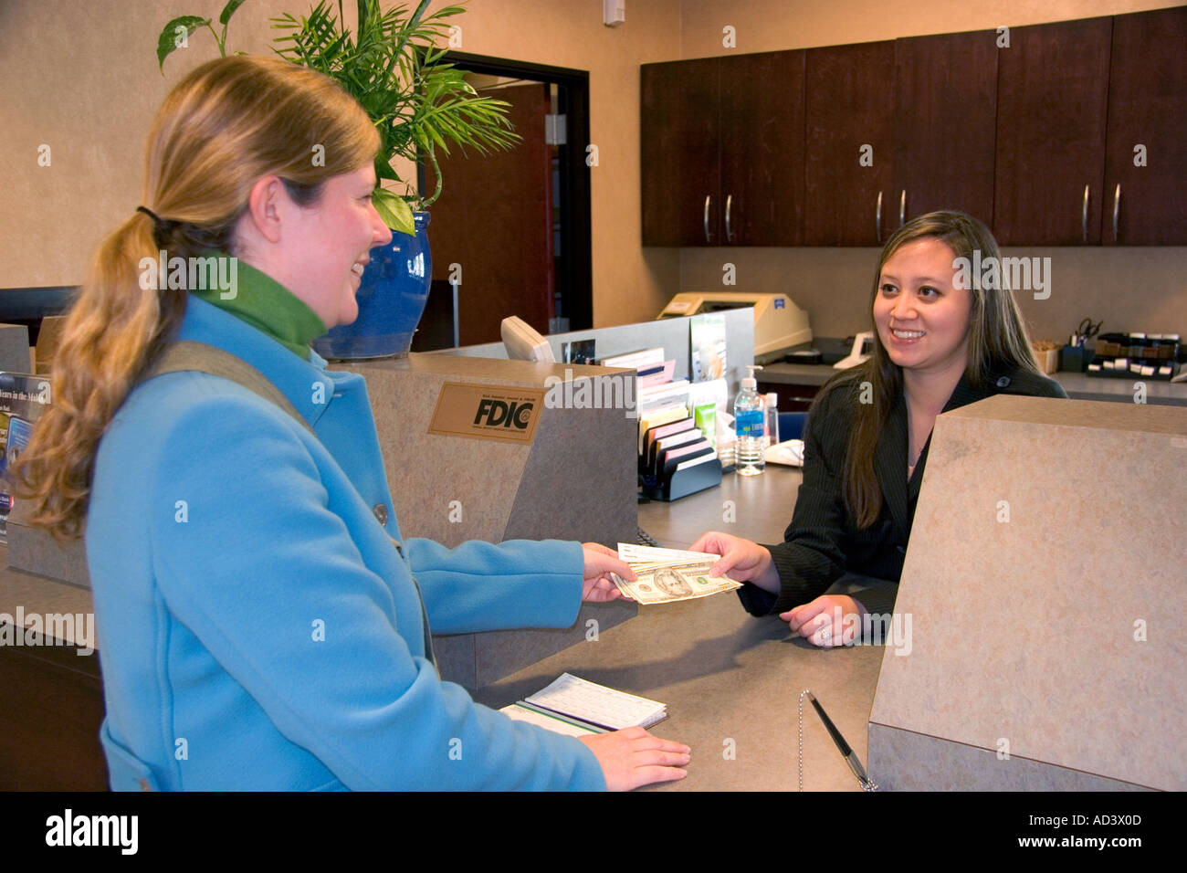 Customer depositing cash at a teller window Stock Photo - Alamy