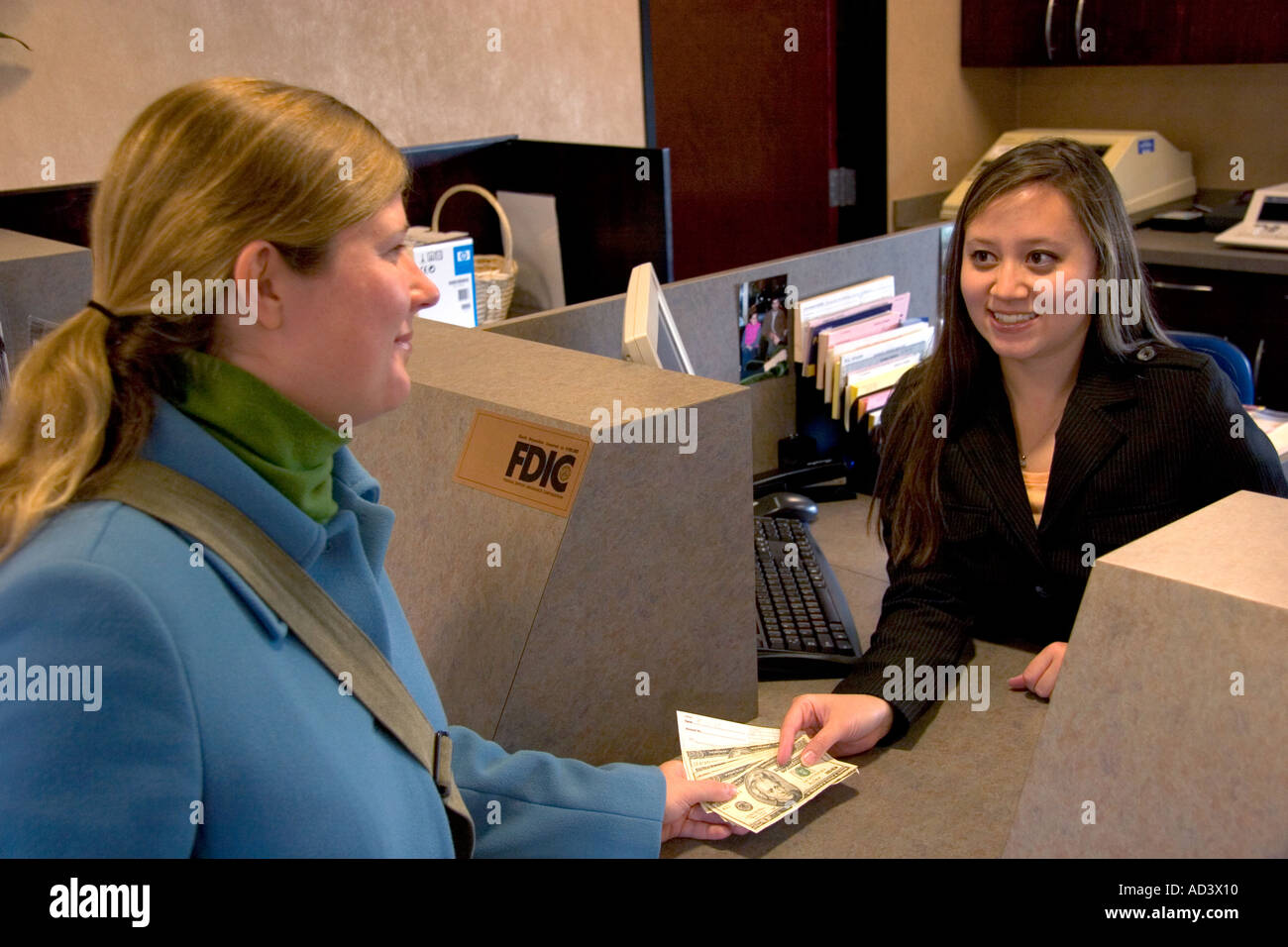 Customer depositing cash at a teller window Stock Photo - Alamy