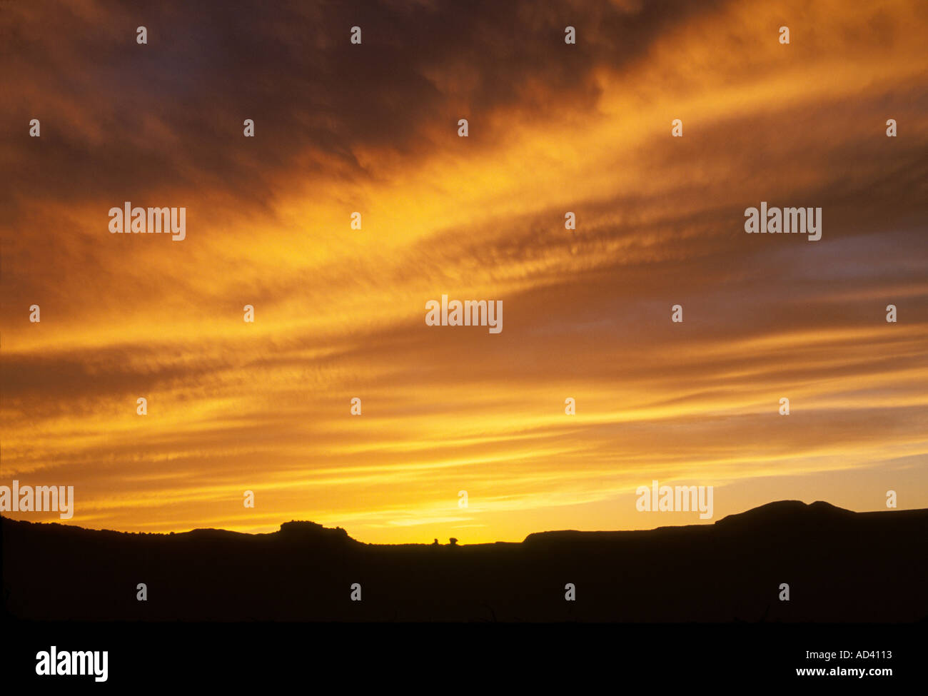 A golden sunset silhouettes Panorama Point in Capitol Reef National ...