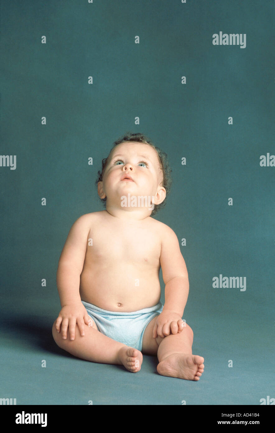 Portrait of seated baby looking upward Stock Photo - Alamy