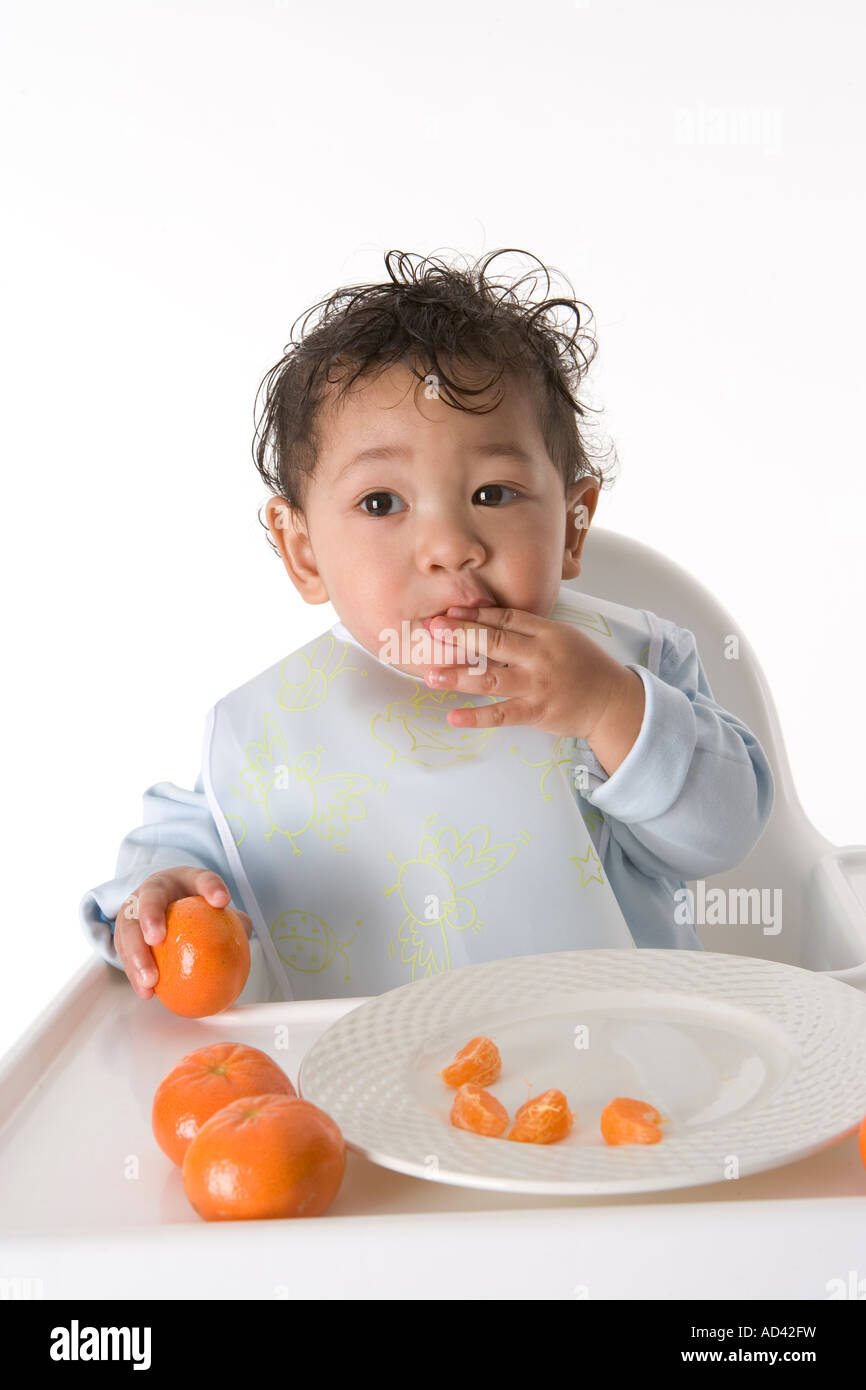 Little boy eating a mandarin Stock Photo - Alamy