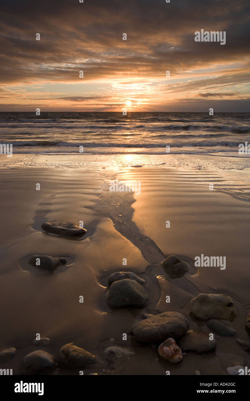 Sunset on a beach Stock Photo - Alamy
