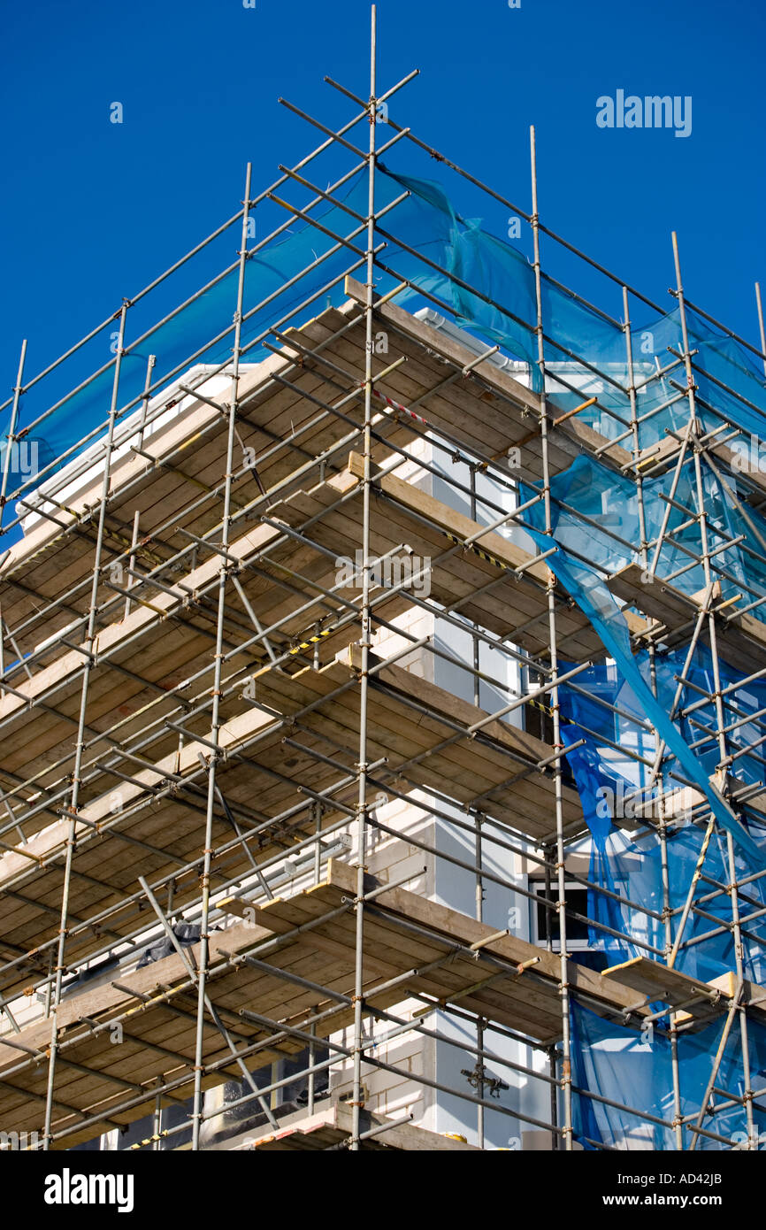 A high scaffolding around a building with a blue sky background Stock ...