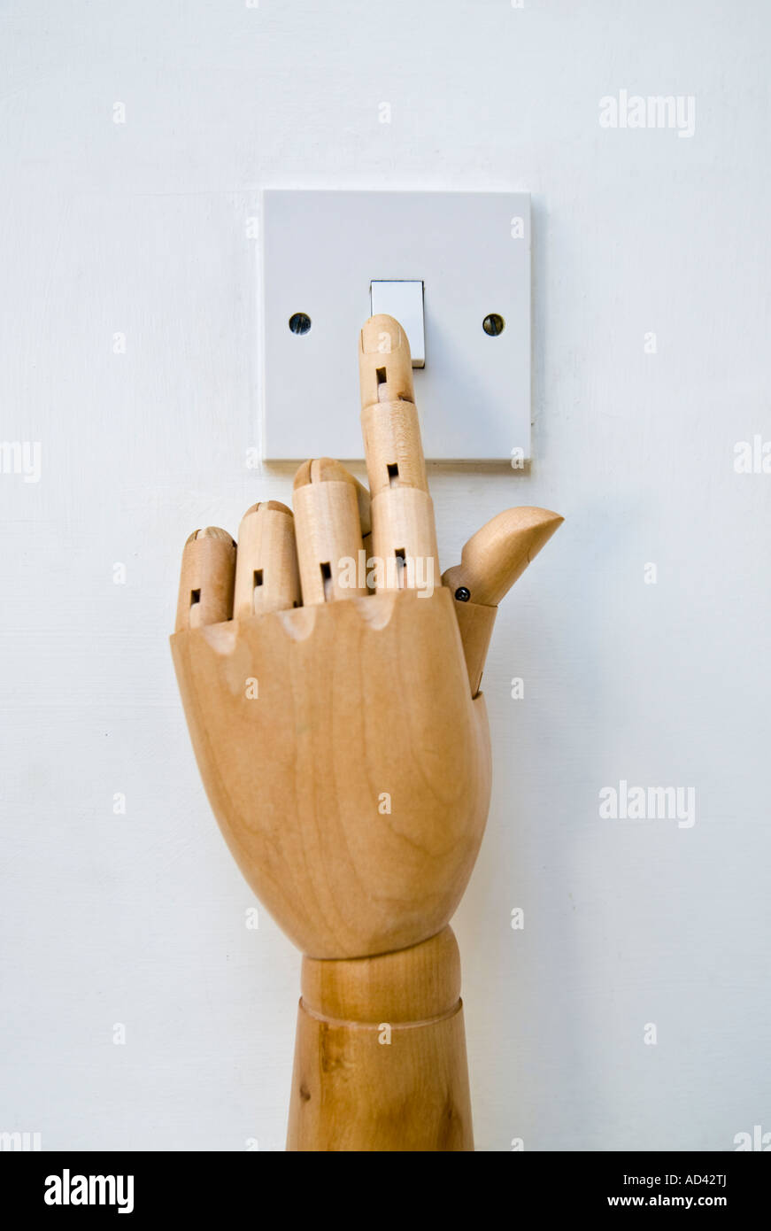wooden hand switching on light switch Stock Photo - Alamy