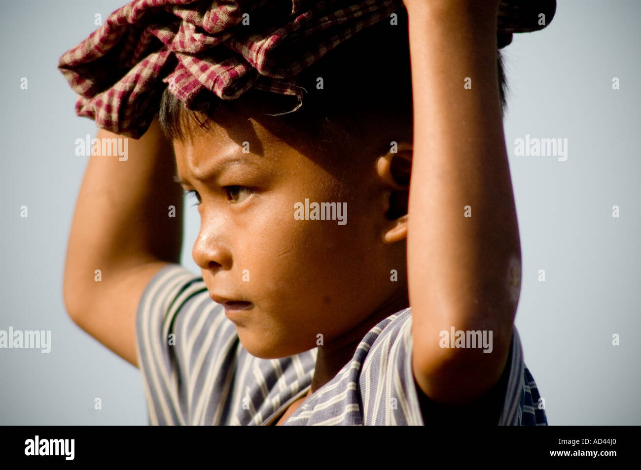 Boy carrying on his head, Phnom Penh Stock Photo - Alamy