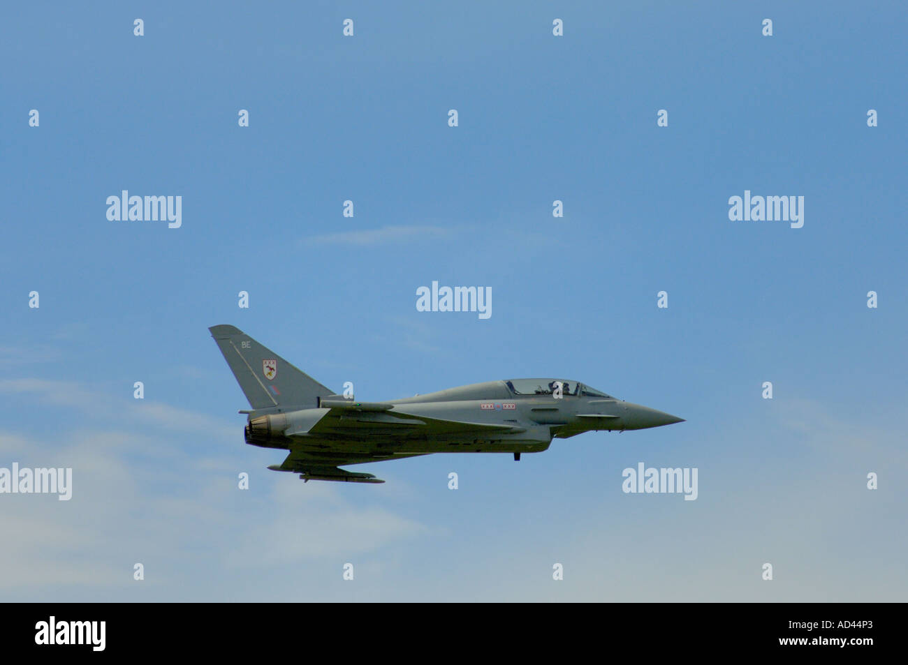 A side-view of a Eurofighter Typhoon in flight, flying in a blue sky ...