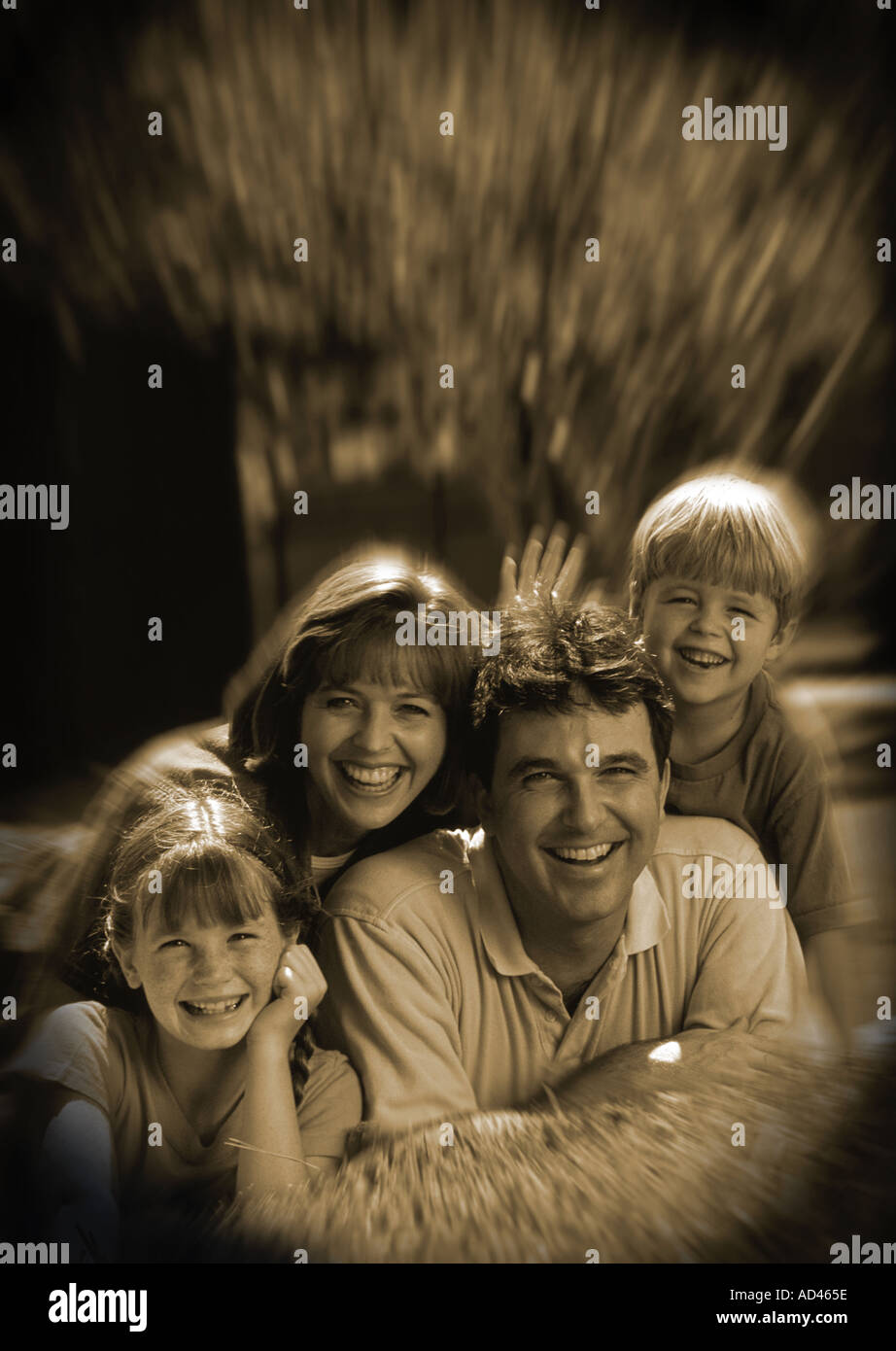 Family portrait with children playing in grass Stock Photo - Alamy