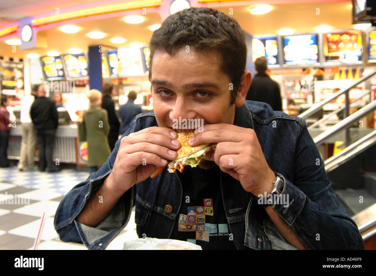 Man eating hamburger at Burger King London England UK Stock Photo - Alamy