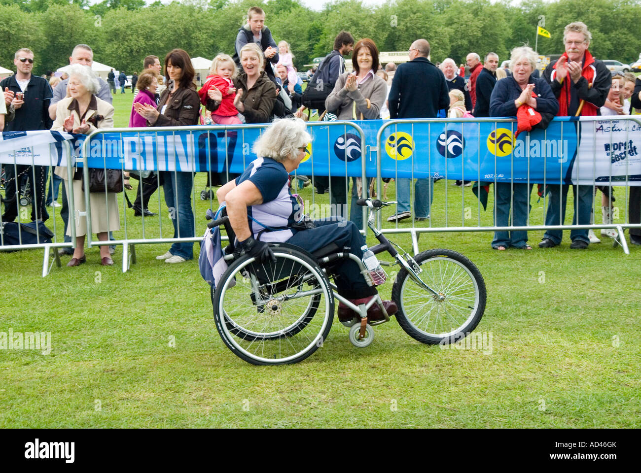 People cheering a disabled woman racing on a wheelchair Stock Photo - Alamy