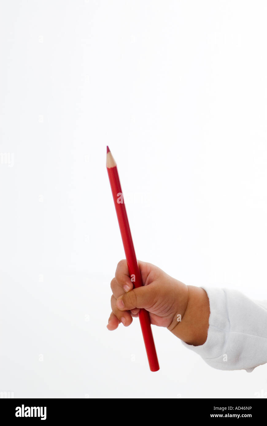 Baby holding red colouring pencil Stock Photo - Alamy