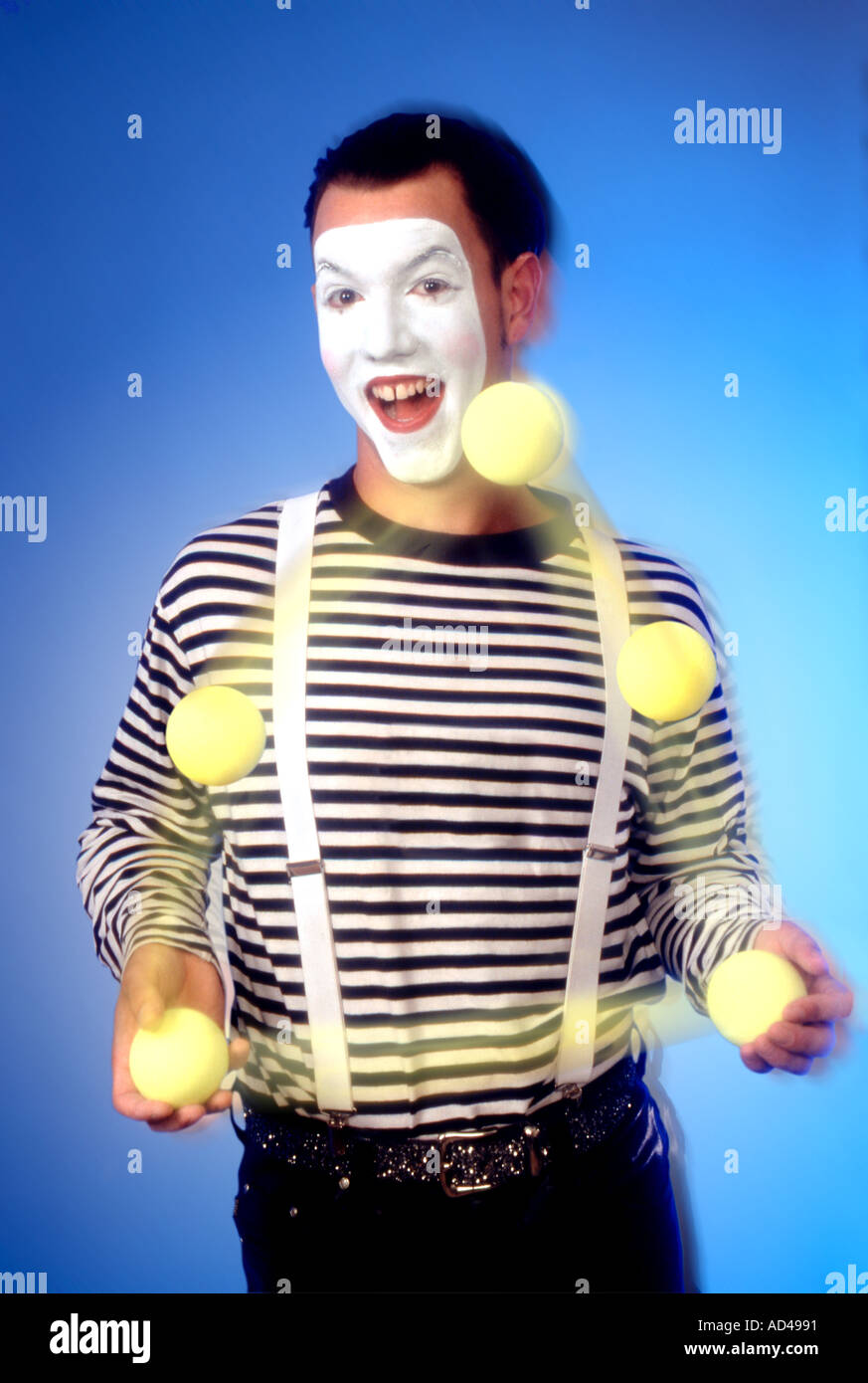 Mime with white painted face with expressive look juggling Stock Photo ...