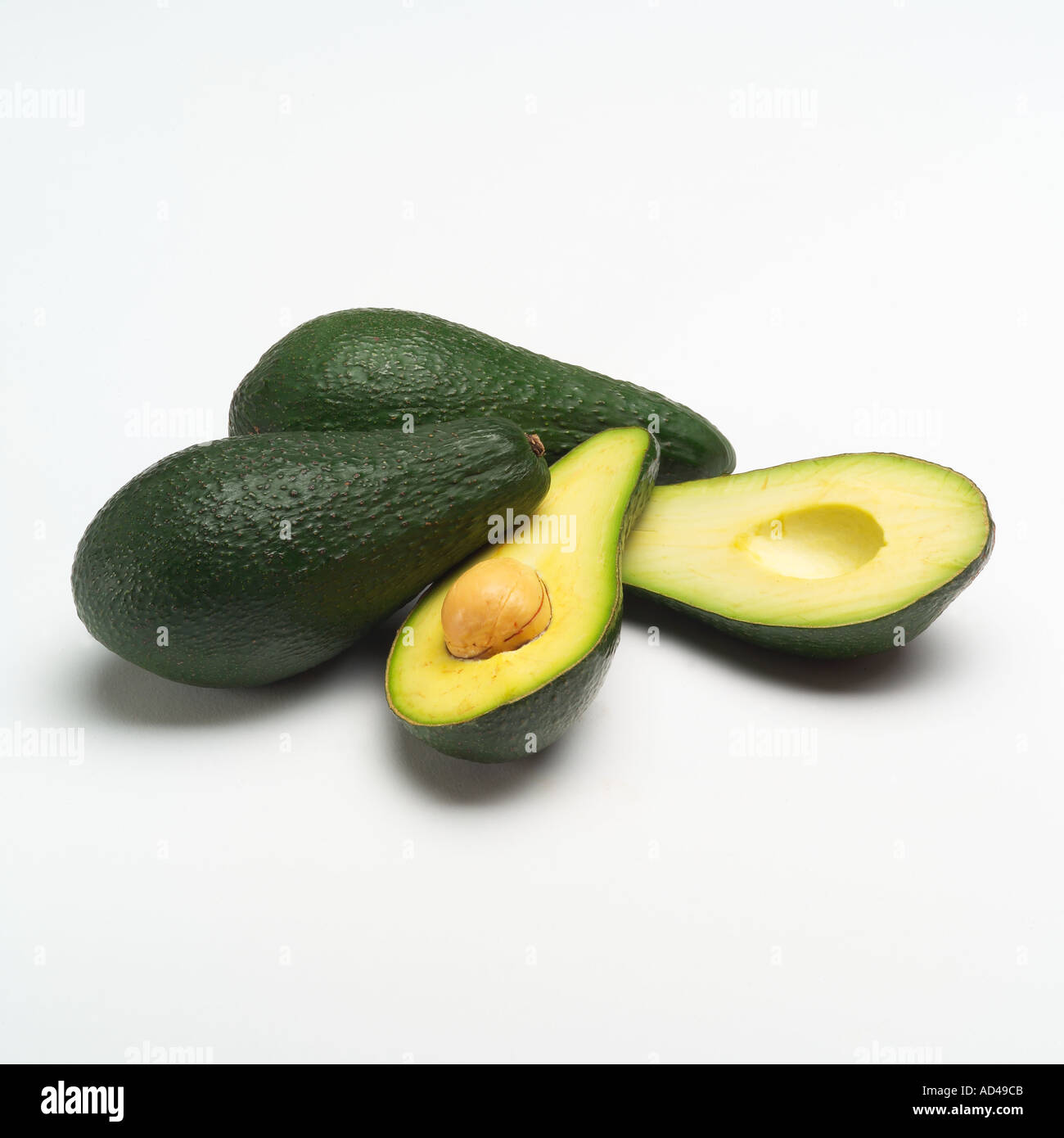 Two halved avocados and 2 whole avocados Stock Photo - Alamy