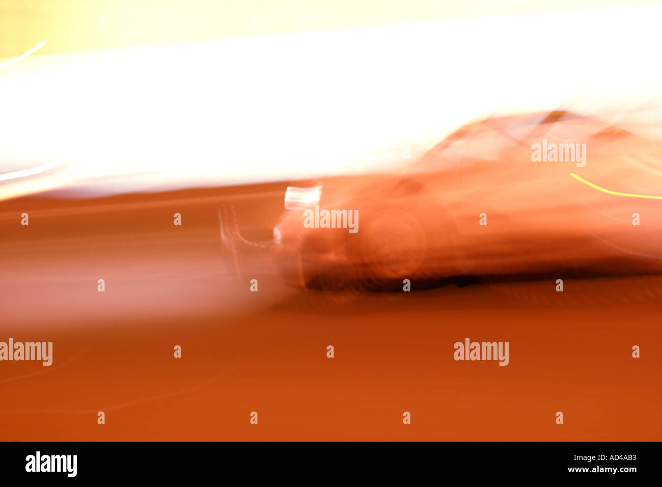 Car moving fast past the camera on a well lit street with evident ...