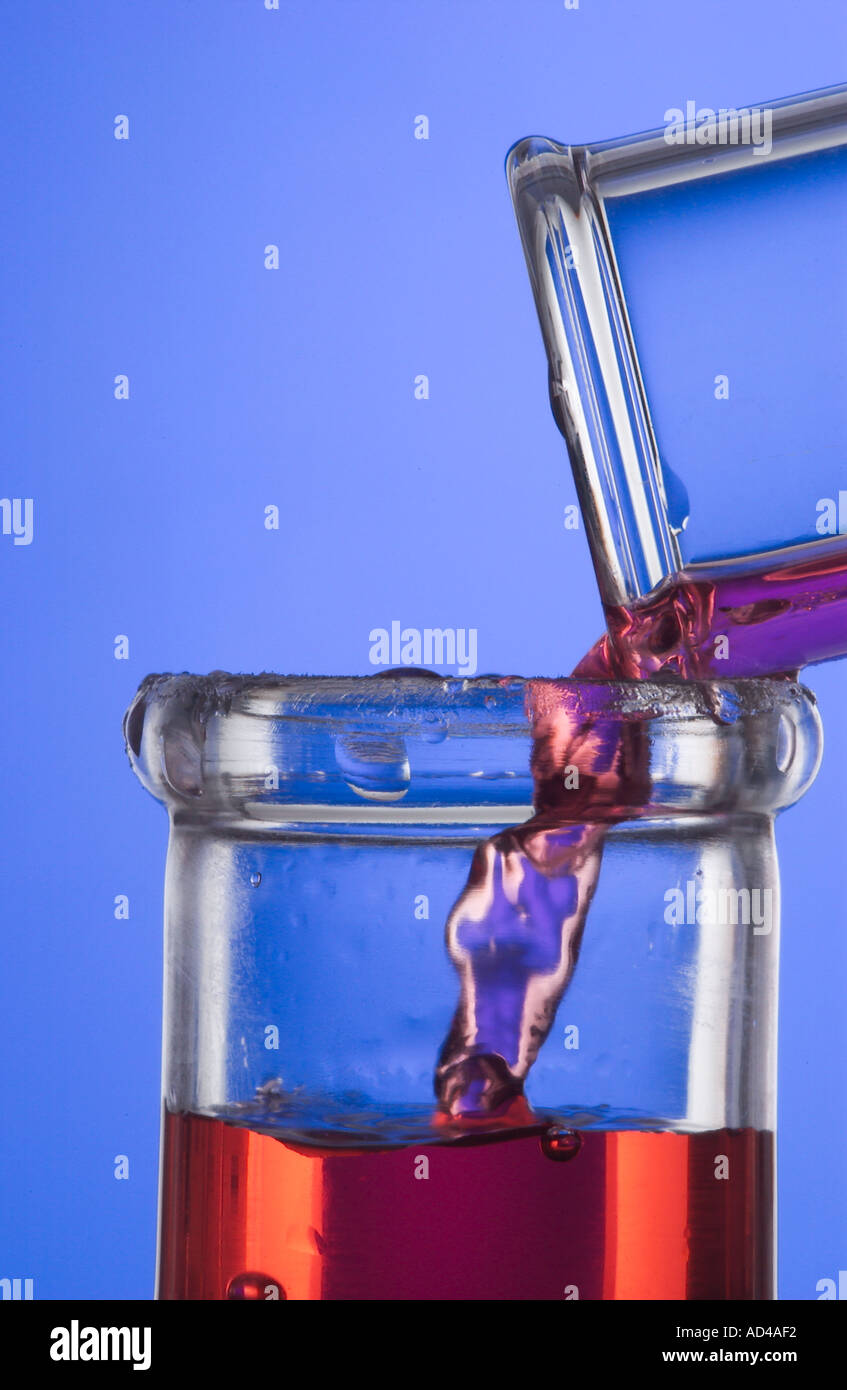 red fluid being poured from test tube into Erlenmeyer flask Stock Photo ...