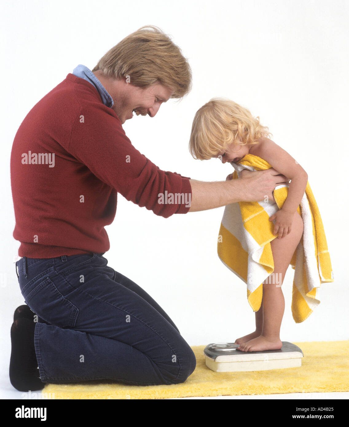 father and small daughter checking weight on bathroom scales Stock ...