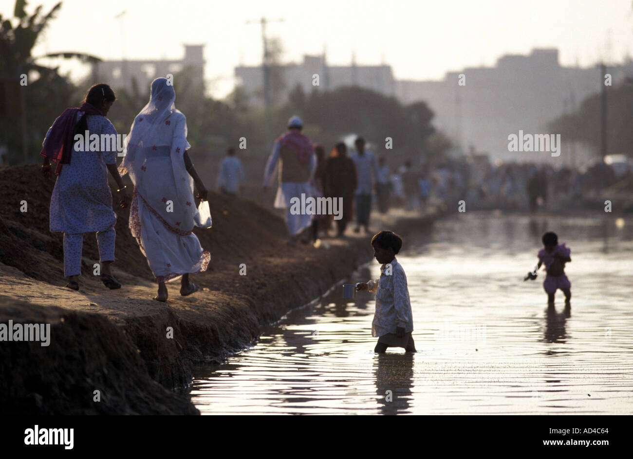 BANGLADESH CHILDREN CROSSING FLOODED RIVER IN THE SLUMS OF DHAKA Stock ...