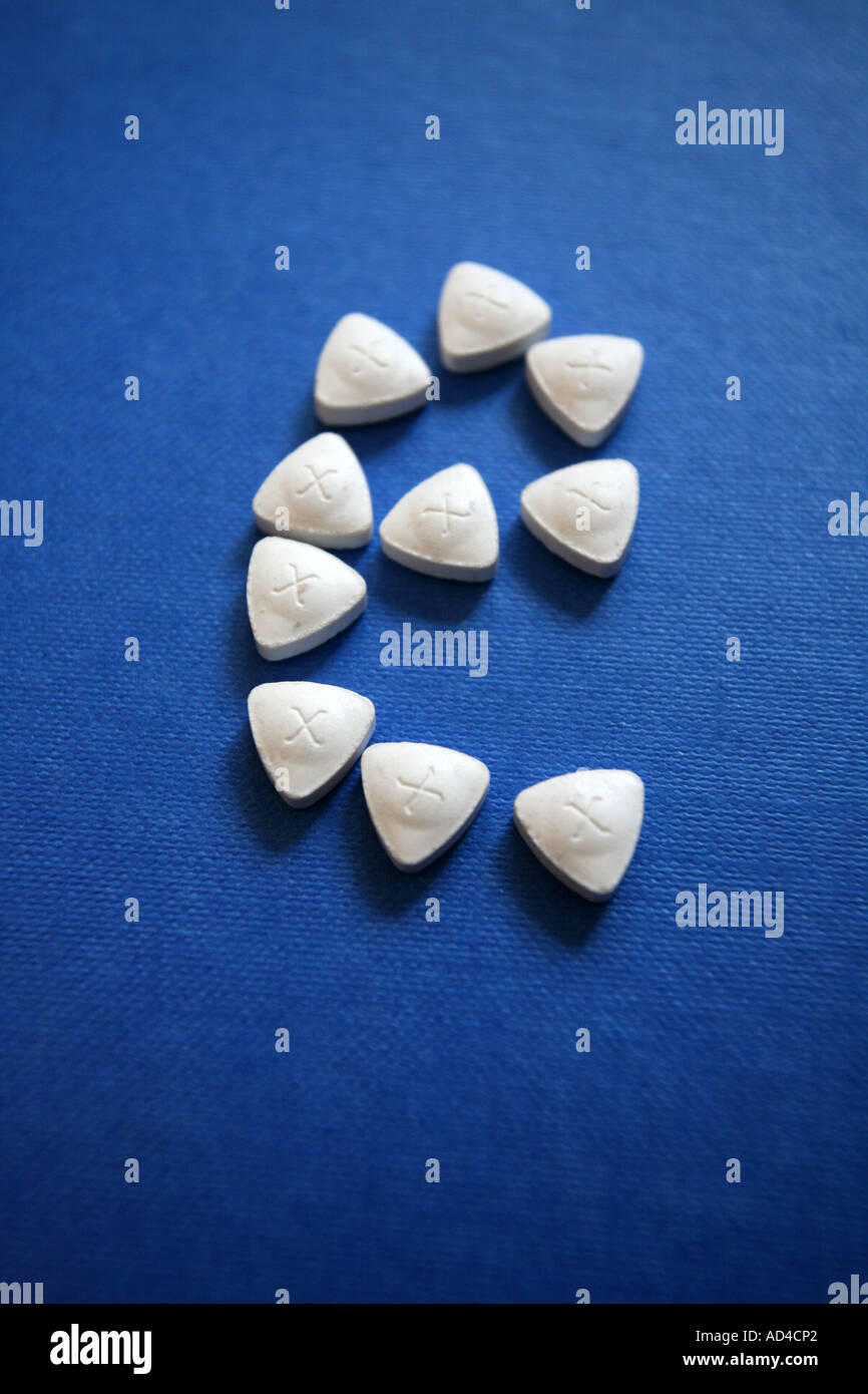 Triangle shaped ecstasy tablets on a blue background Stock Photo - Alamy