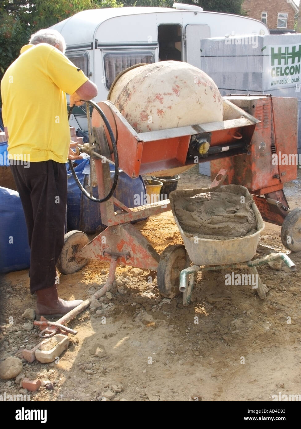 Building site for new house labourer operating diesel powered cement ...