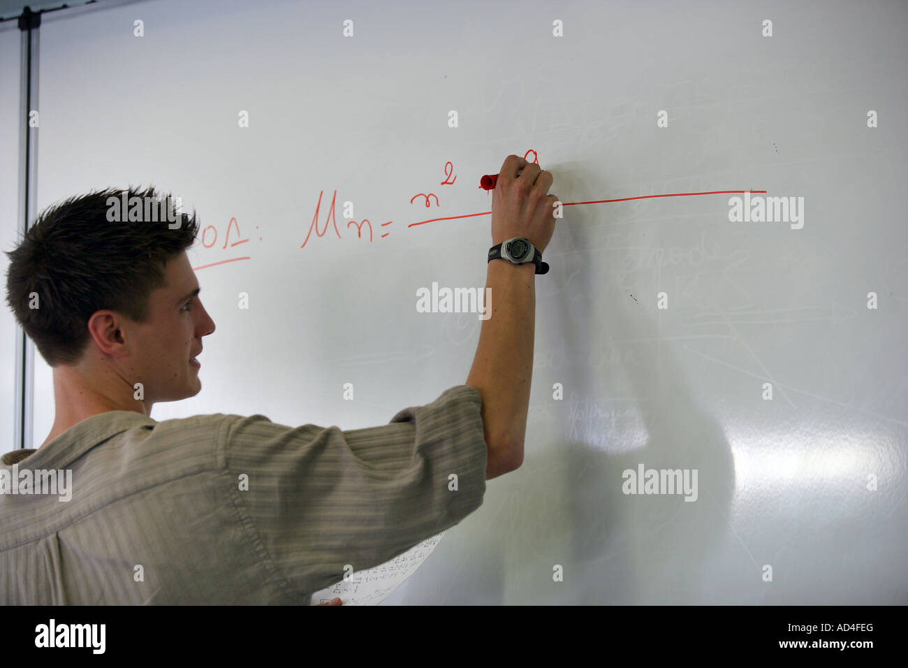 Student writing on a board Stock Photo - Alamy