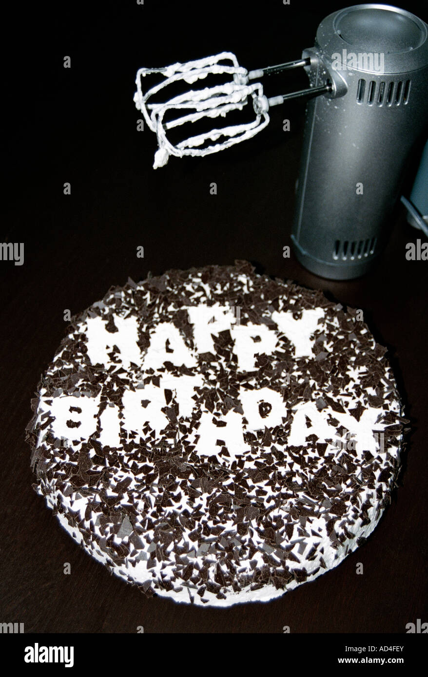 An electric mixer next to a birthday cake Stock Photo - Alamy