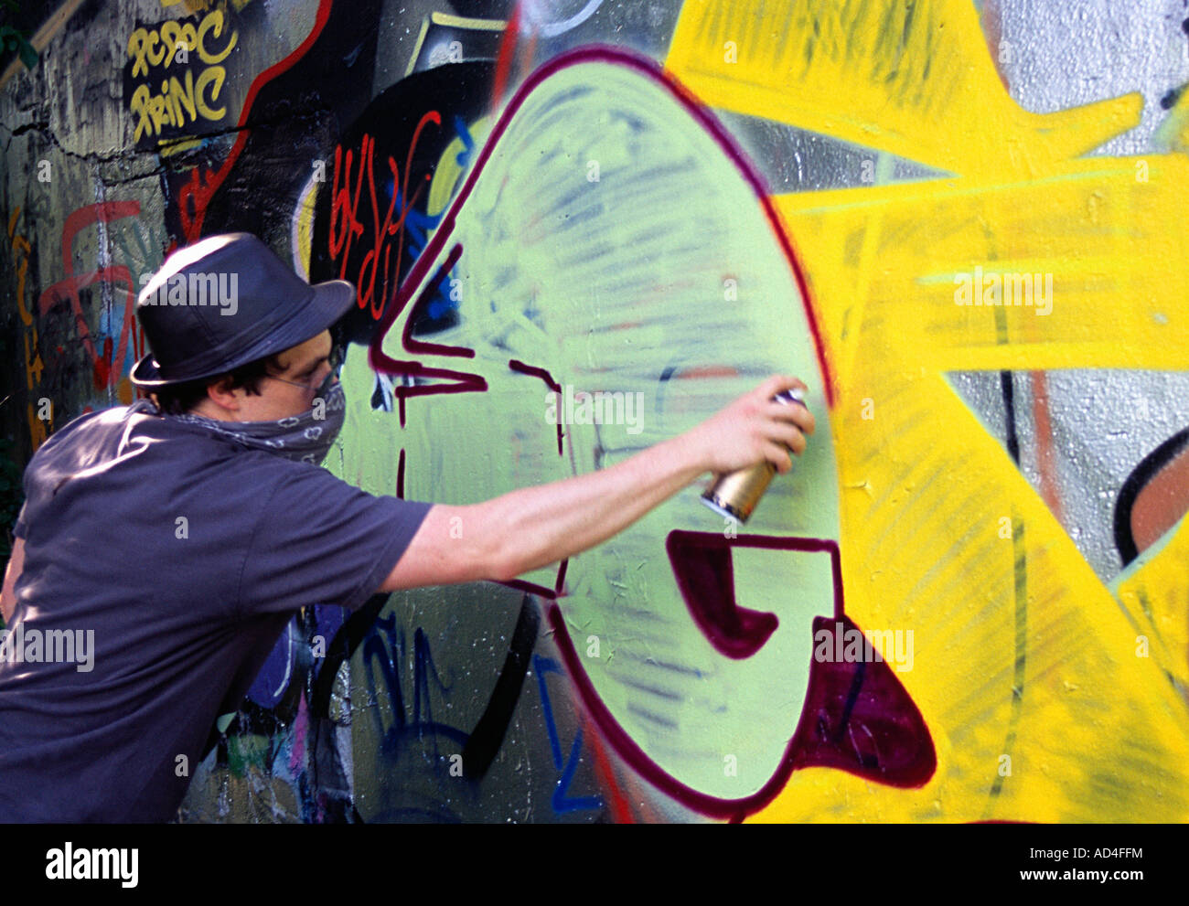 A man spraying paint on a wall Stock Photo - Alamy