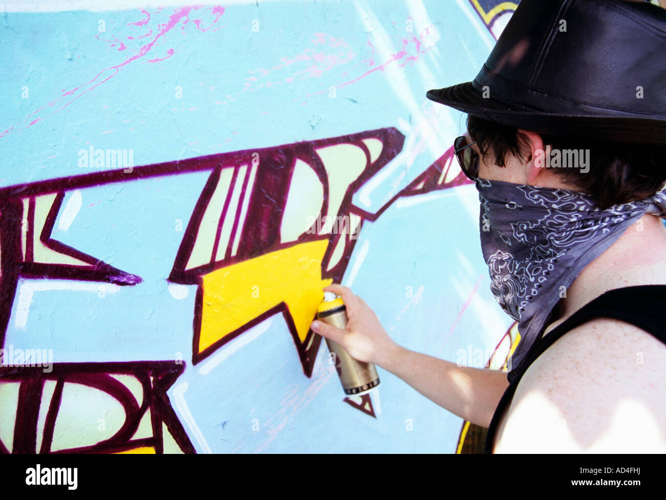A man spraying paint on a wall Stock Photo - Alamy