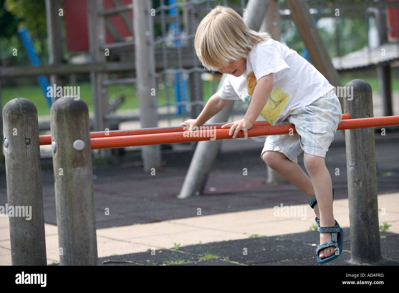 Boy at a climbing pole at the playground Stock Photo - Alamy
